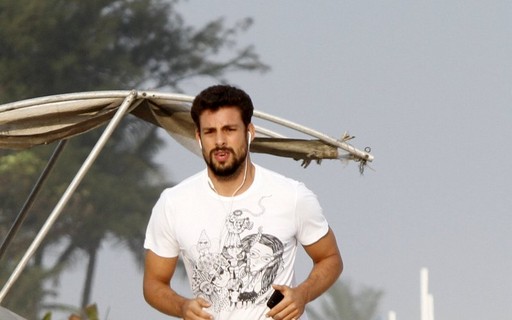Com barba e cabelo grande, Cauã Reymond se exercita correndo na praia ...