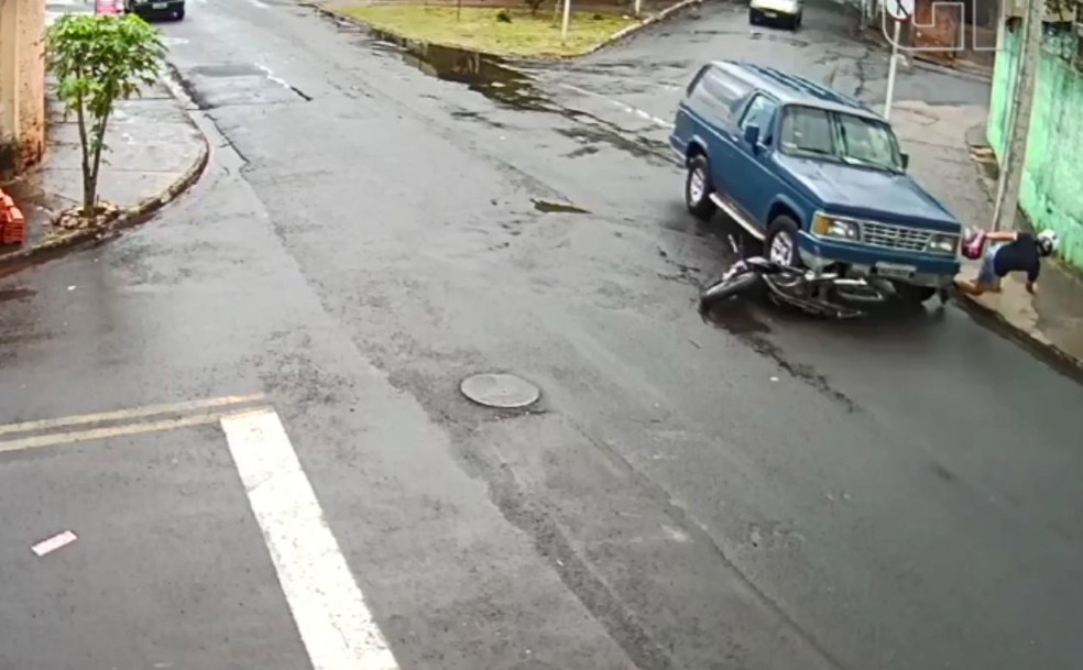Motociclista escorrega na rua molhada pela chuva e atinge caminhonete ...