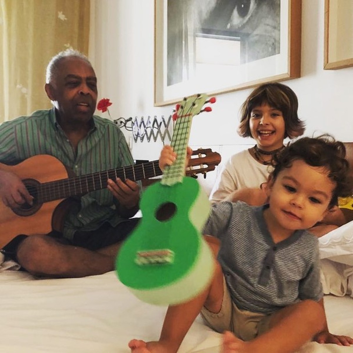 Gilberto Gil posa na cama tocando violão com filhos de Bela Gil ...
